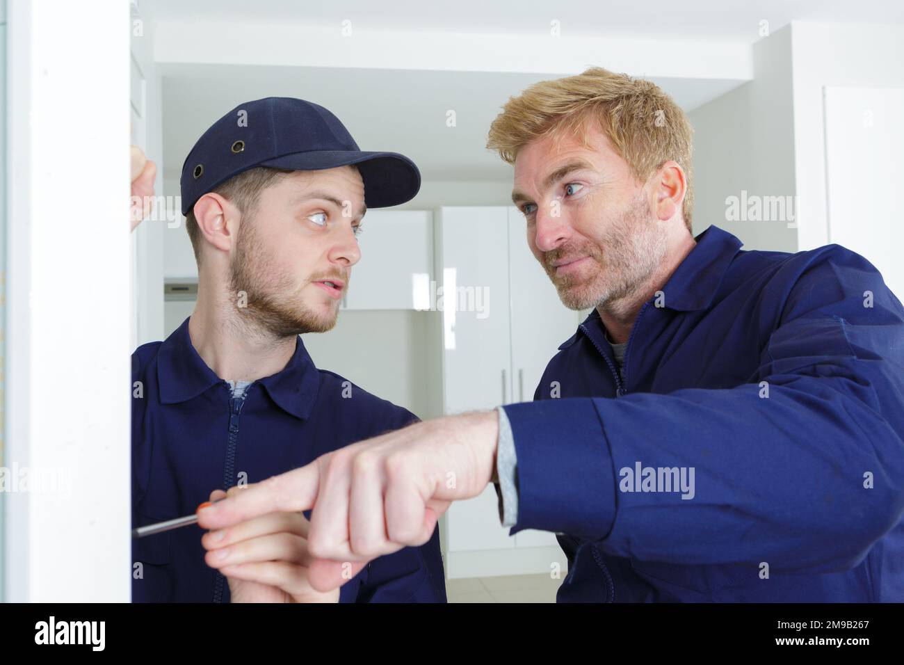 worker and apprentice installing new window Stock Photo - Alamy