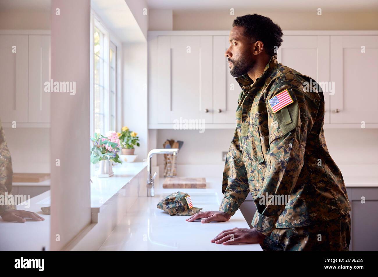 Thoughtful Male American Soldier In Uniform In Kitchen On Home Leave ...