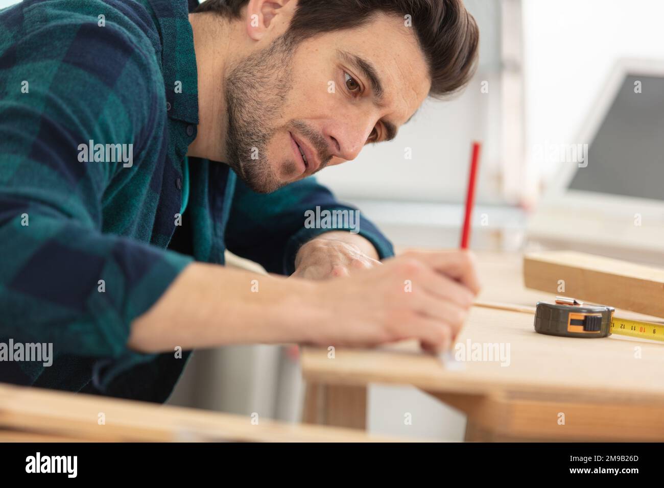 a carpenter marking a hole in a furniture part Stock Photo - Alamy