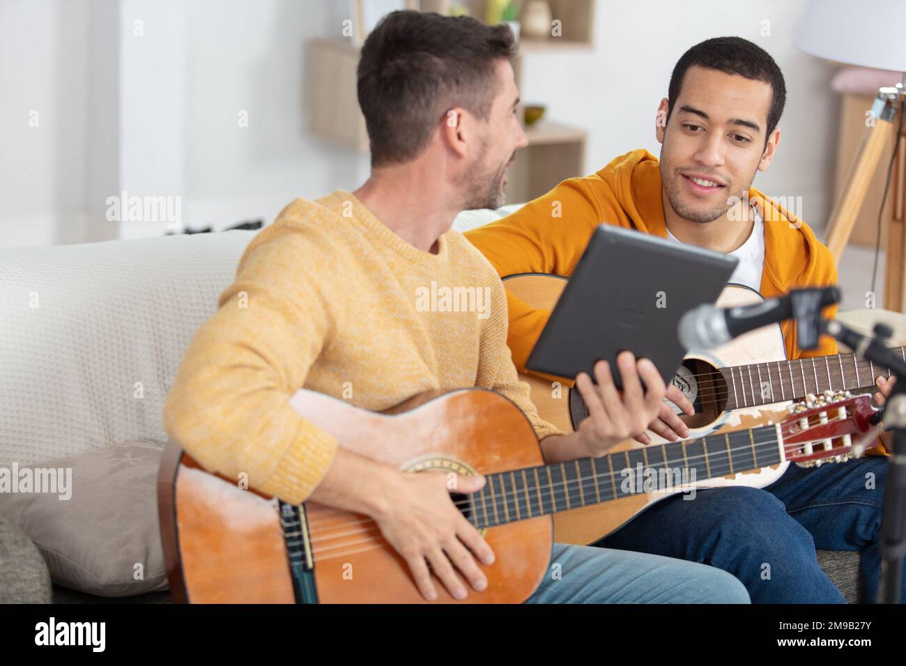 musician teaching his friend playing guitar Stock Photo - Alamy