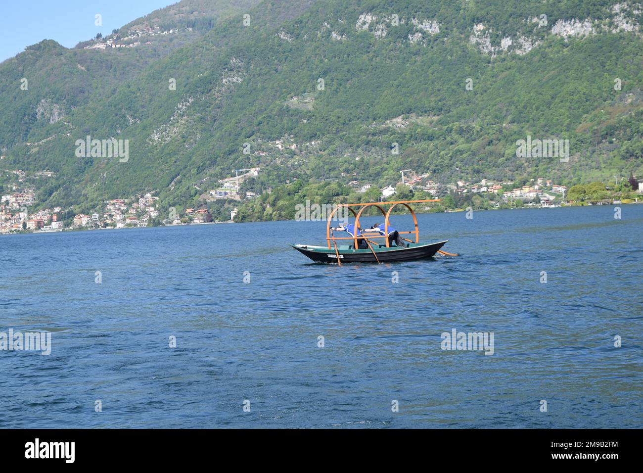 Rowers rowing a traditional boat on Lake Como, Italy Stock Photo - Alamy