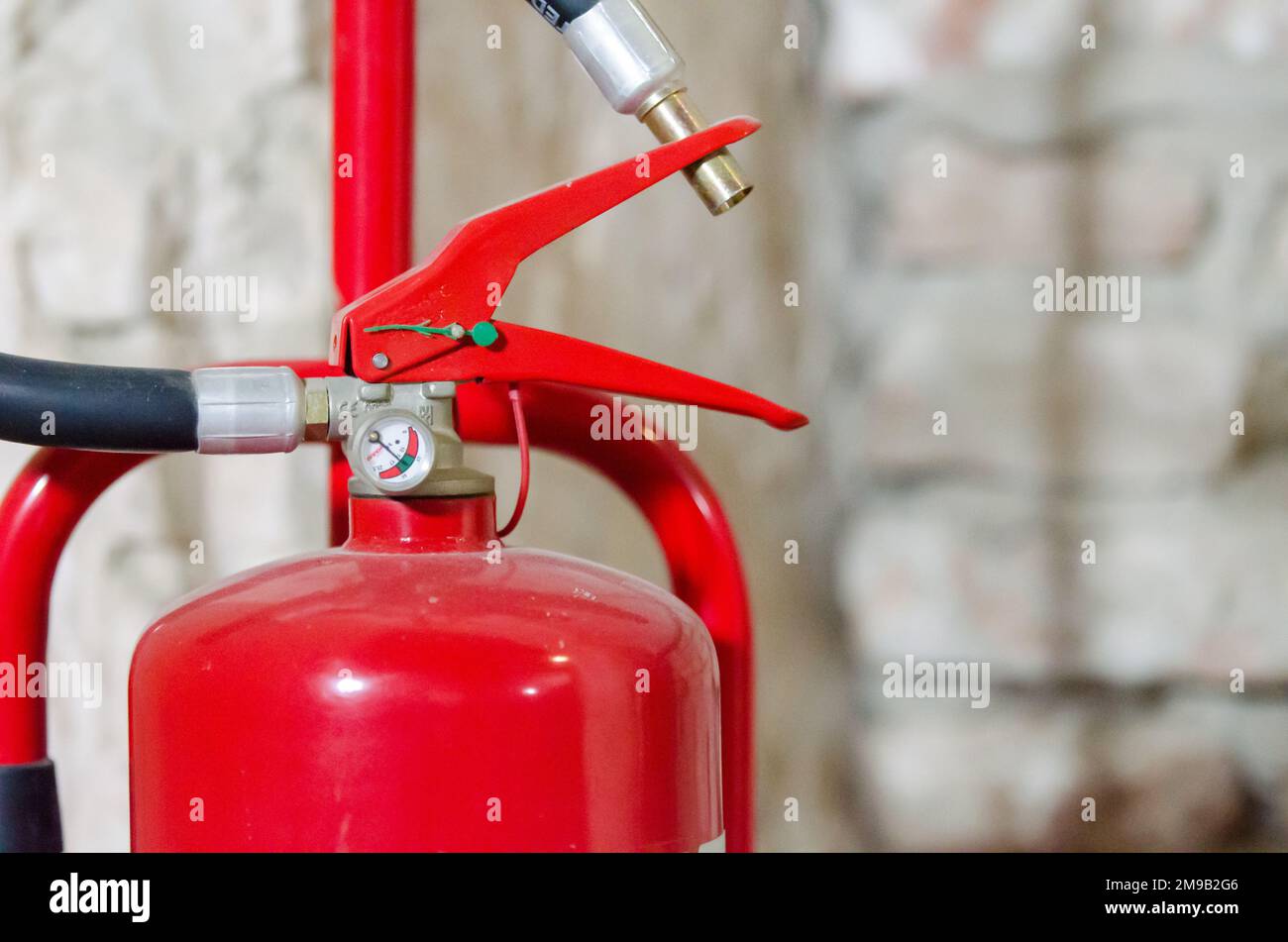 A closeup of a red fire extinguisher on a blurry background Stock Photo ...