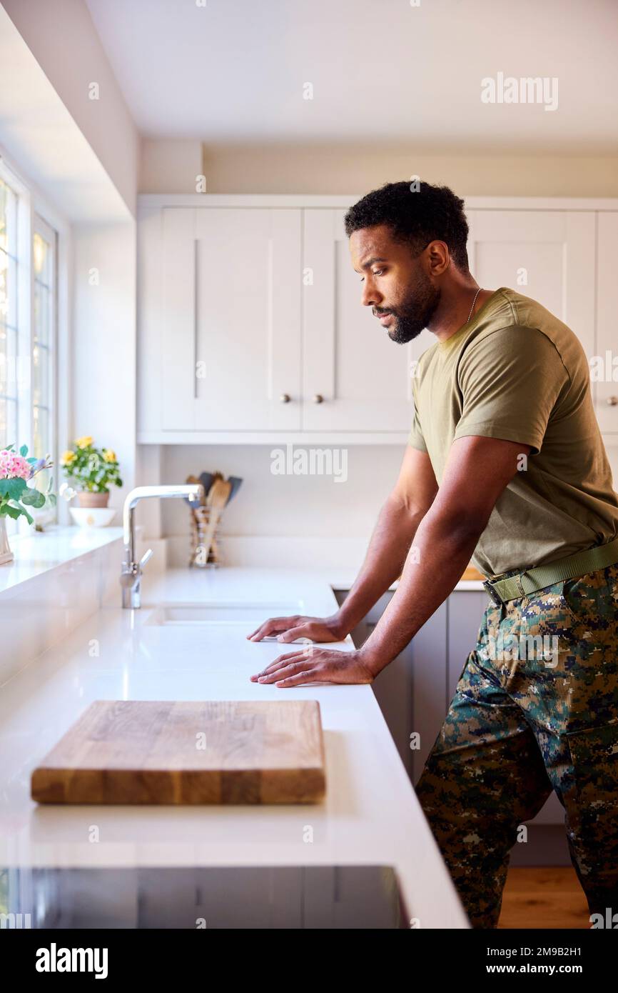 Thoughtful Male American Soldier In Uniform In Kitchen On Home Leave ...
