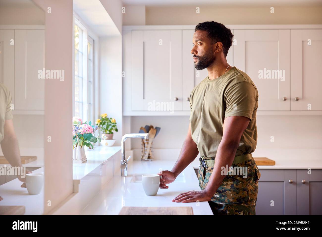 Thoughtful Male American Soldier In Uniform In Kitchen On Home Leave ...