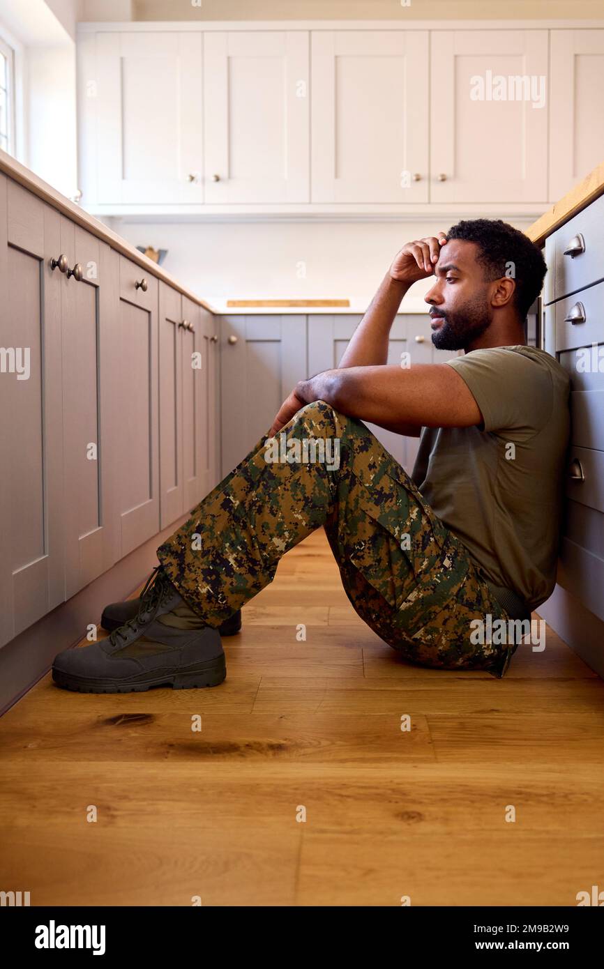 Depressed Male Soldier In Uniform Suffering With PTSD Sitting On ...