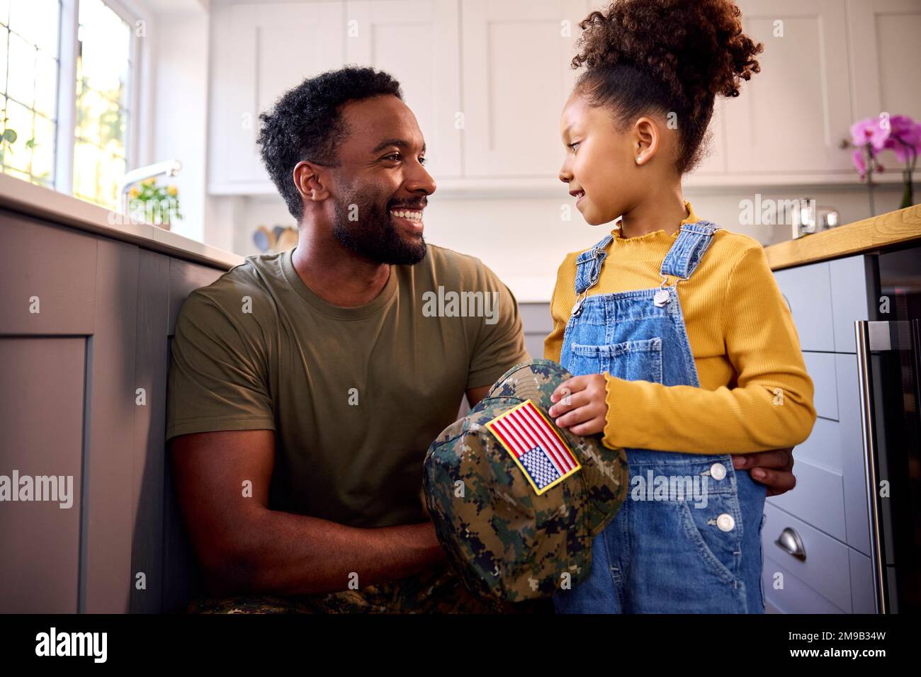 Daughter Holding Cap Of American Army Father In Uniform Home On Leave ...