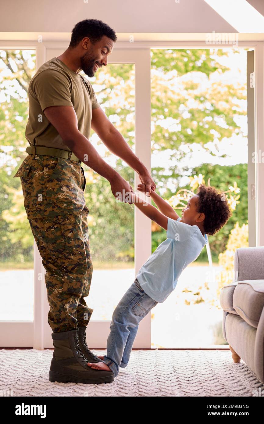 Loving Army Father In Uniform Home On Leave With Son Standing On Feet ...
