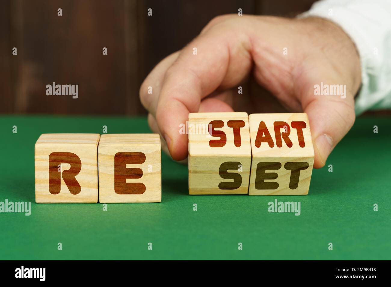 Technology concept. On a green surface, a man puts cubes with the ...