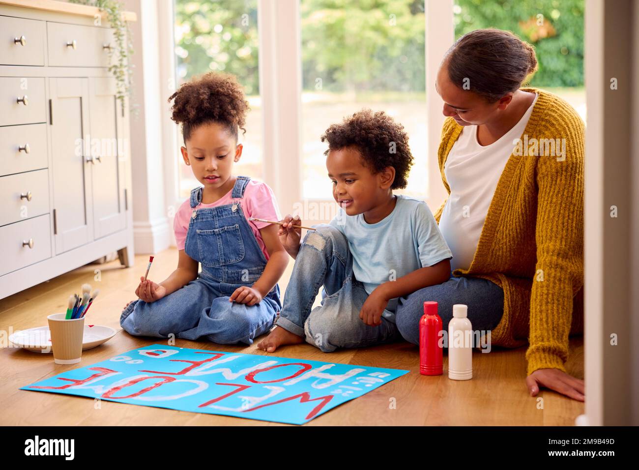 Pregnant Mother With Children Making Welcome Home Banner For Army ...