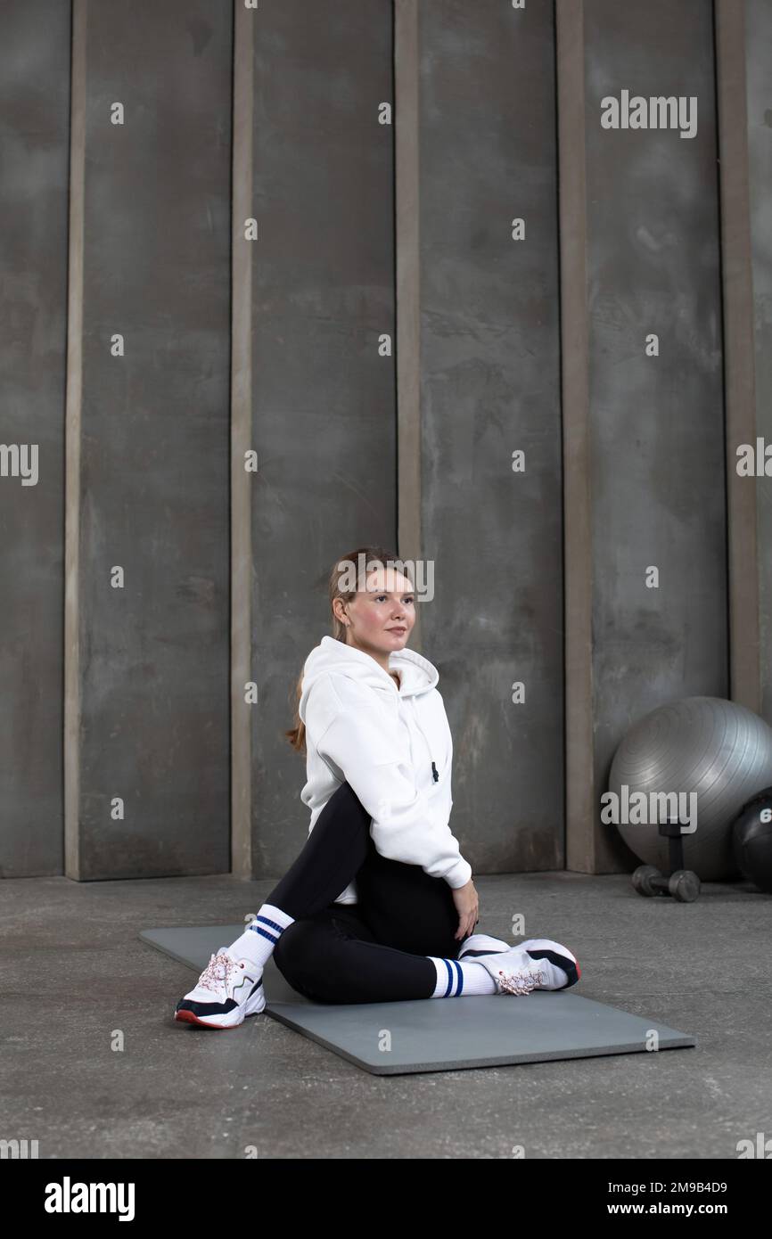 The athlete twists her back muscles during Pilates. The pose of the ...