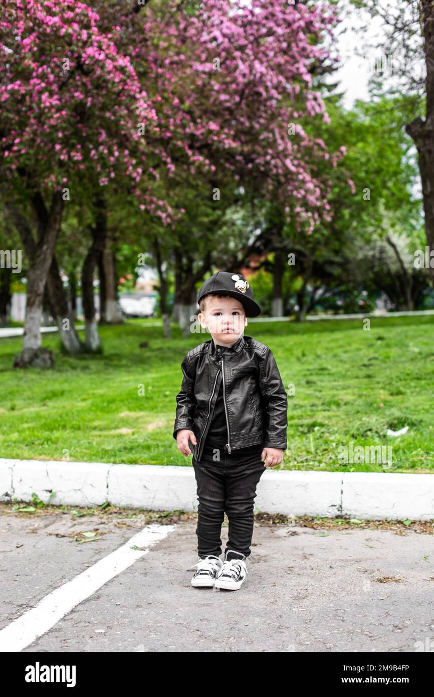 Boy in the spring park with blossom tree Stock Photo - Alamy