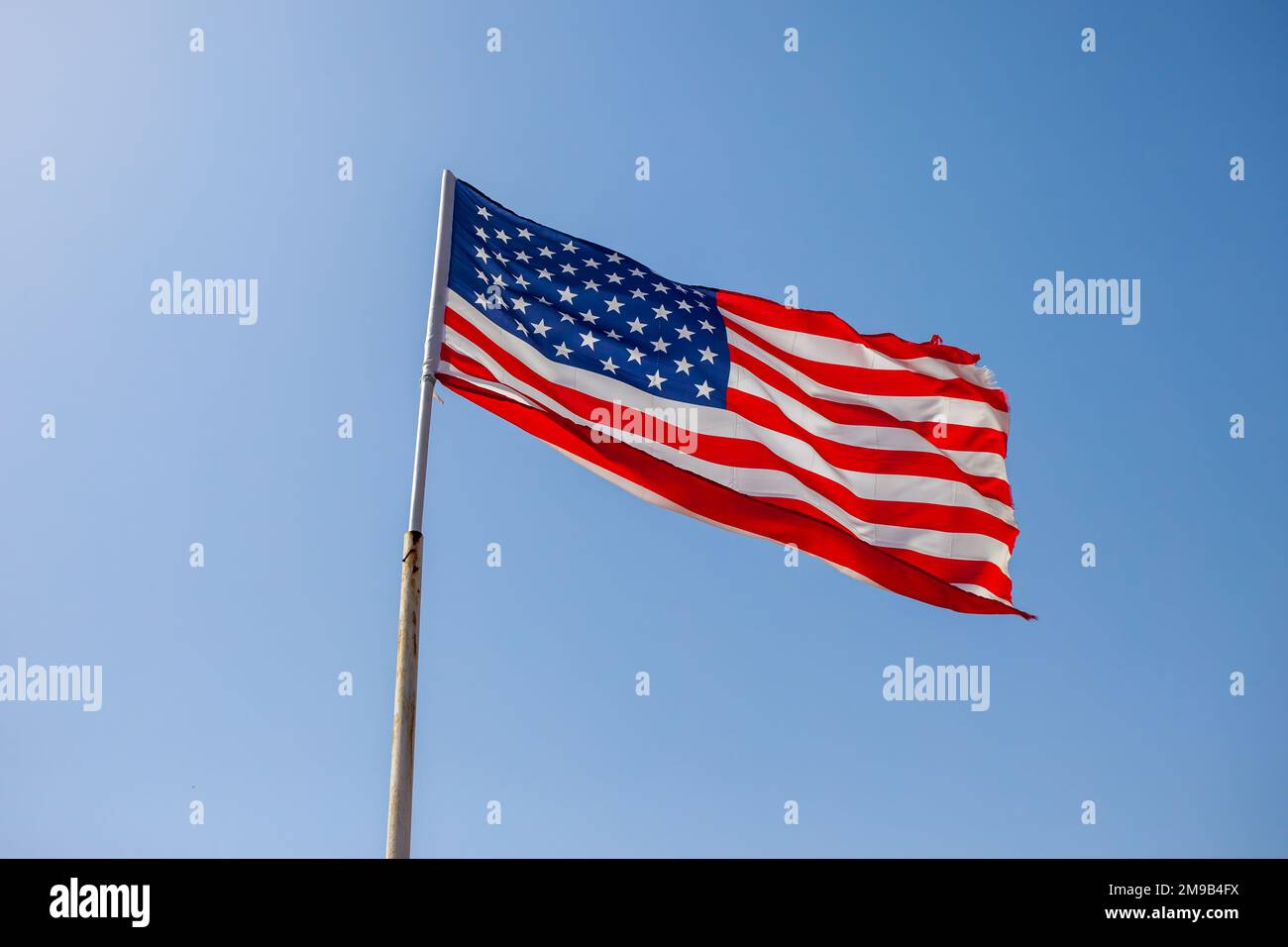 American Flag Against Clear Blue Sky Stock Photo - Alamy