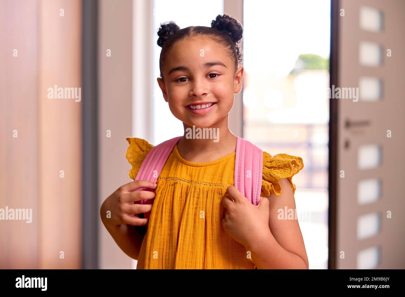 Portrait Of Smiling Girl Wearing Backpack In Hallway At Home Ready For ...