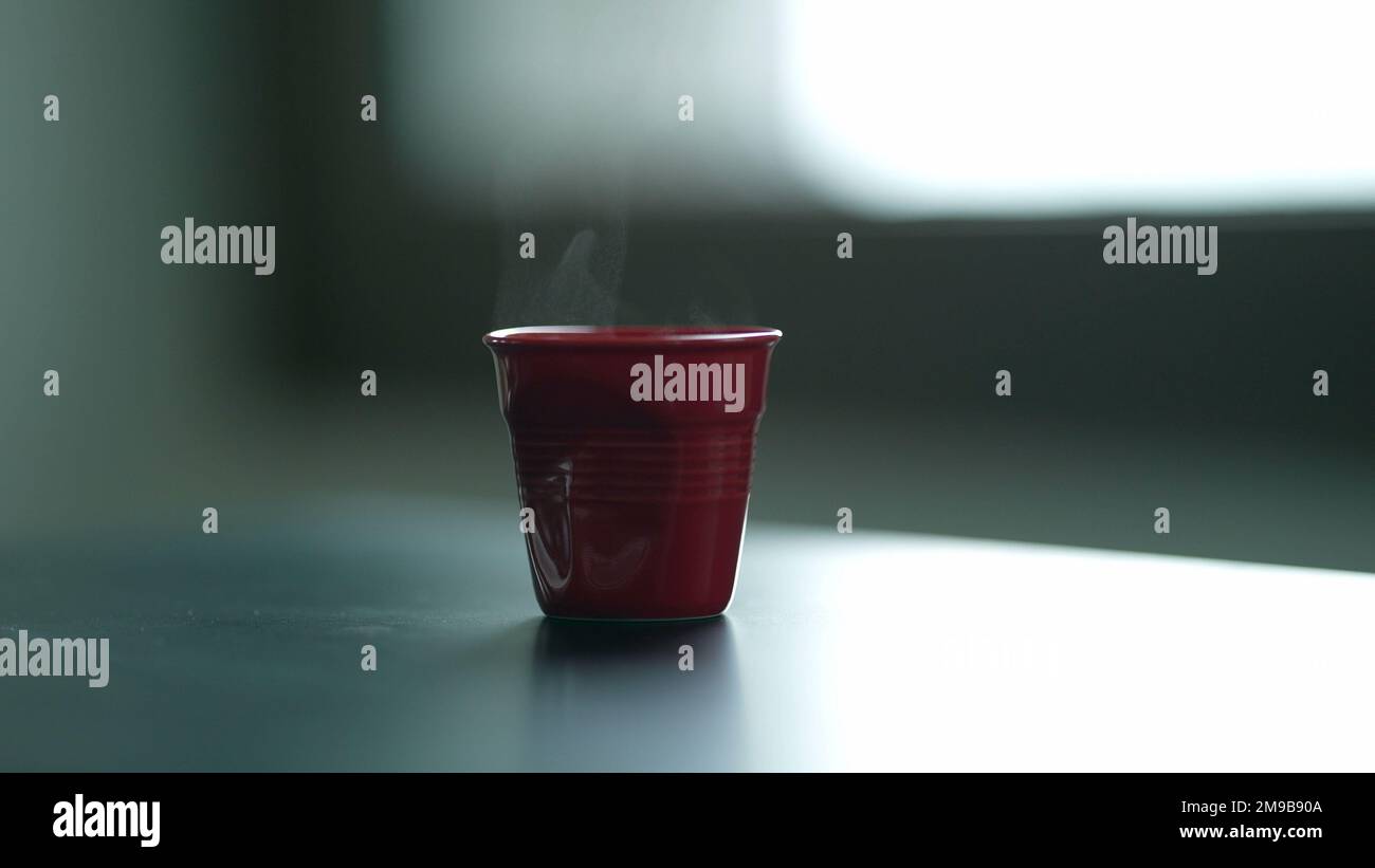 Steam coming out from cup of coffee. Red color cup Stock Photo - Alamy