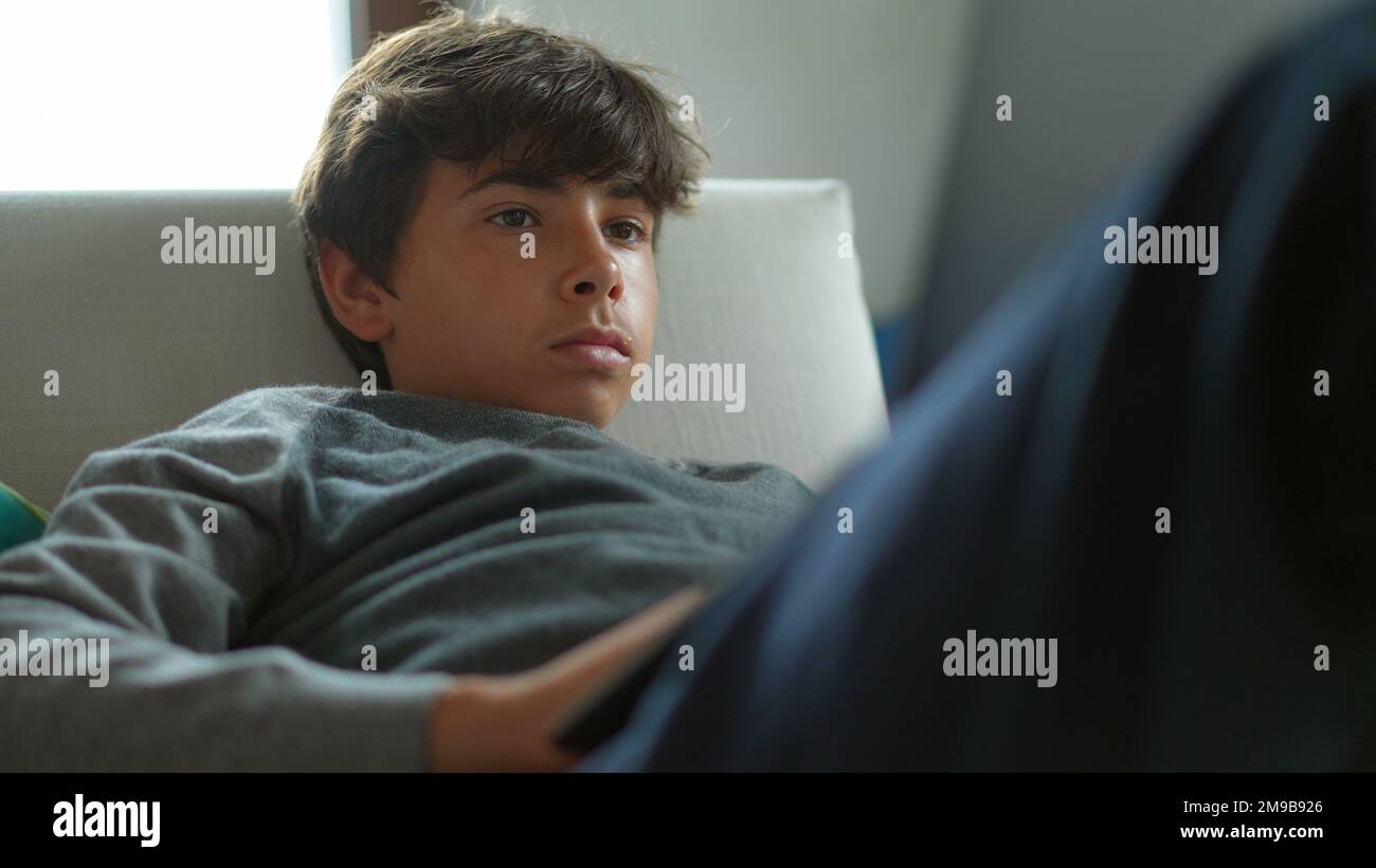 Young boy using laptop at home. Kid staring at computer screen sitting ...