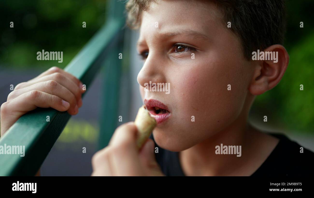 Spectator child watching match while eating ice-cream cone. kid ...