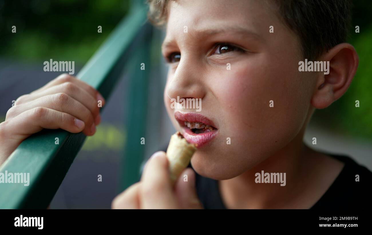 Spectator child watching match while eating ice-cream cone. kid ...