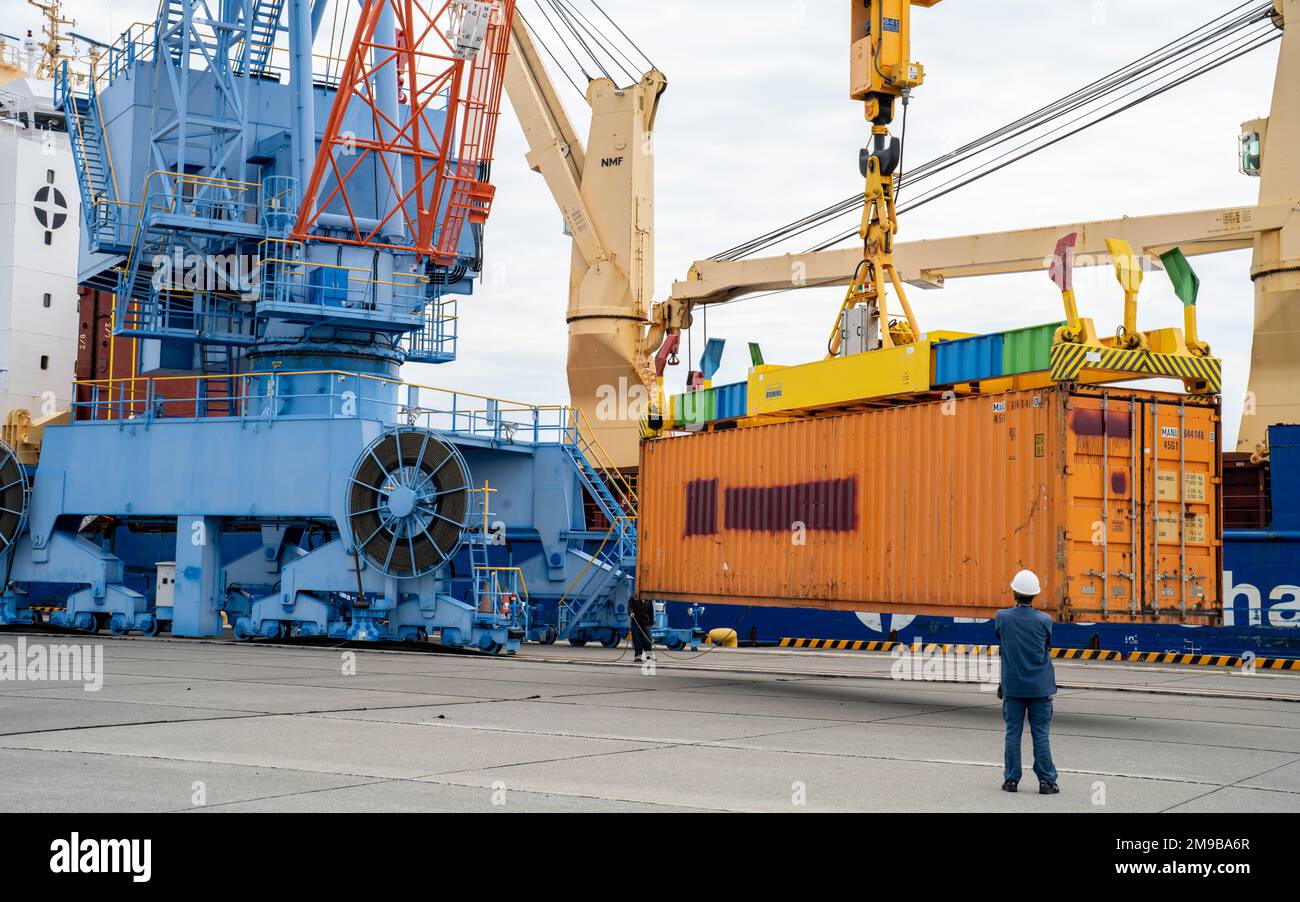 Japanese dockworkers offload a shipping container holding equipment ...