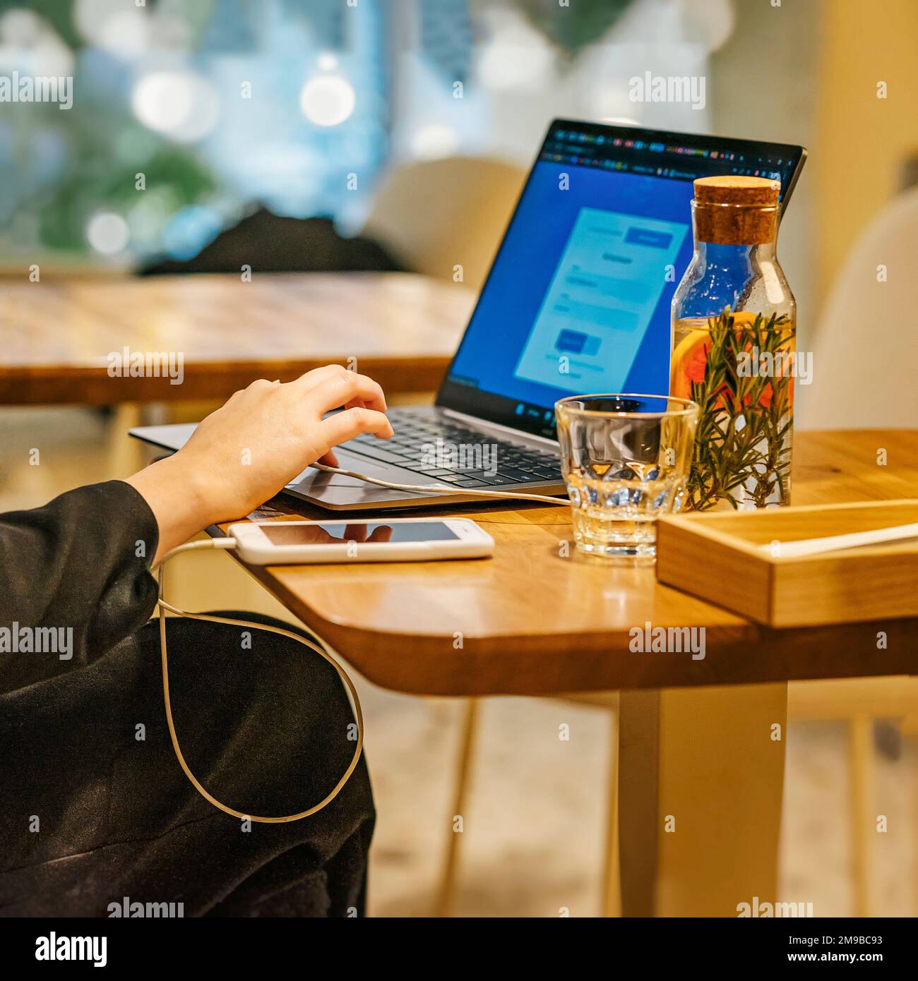Workspace inside cafe, girl hands, laptop computer, mobile phone ...