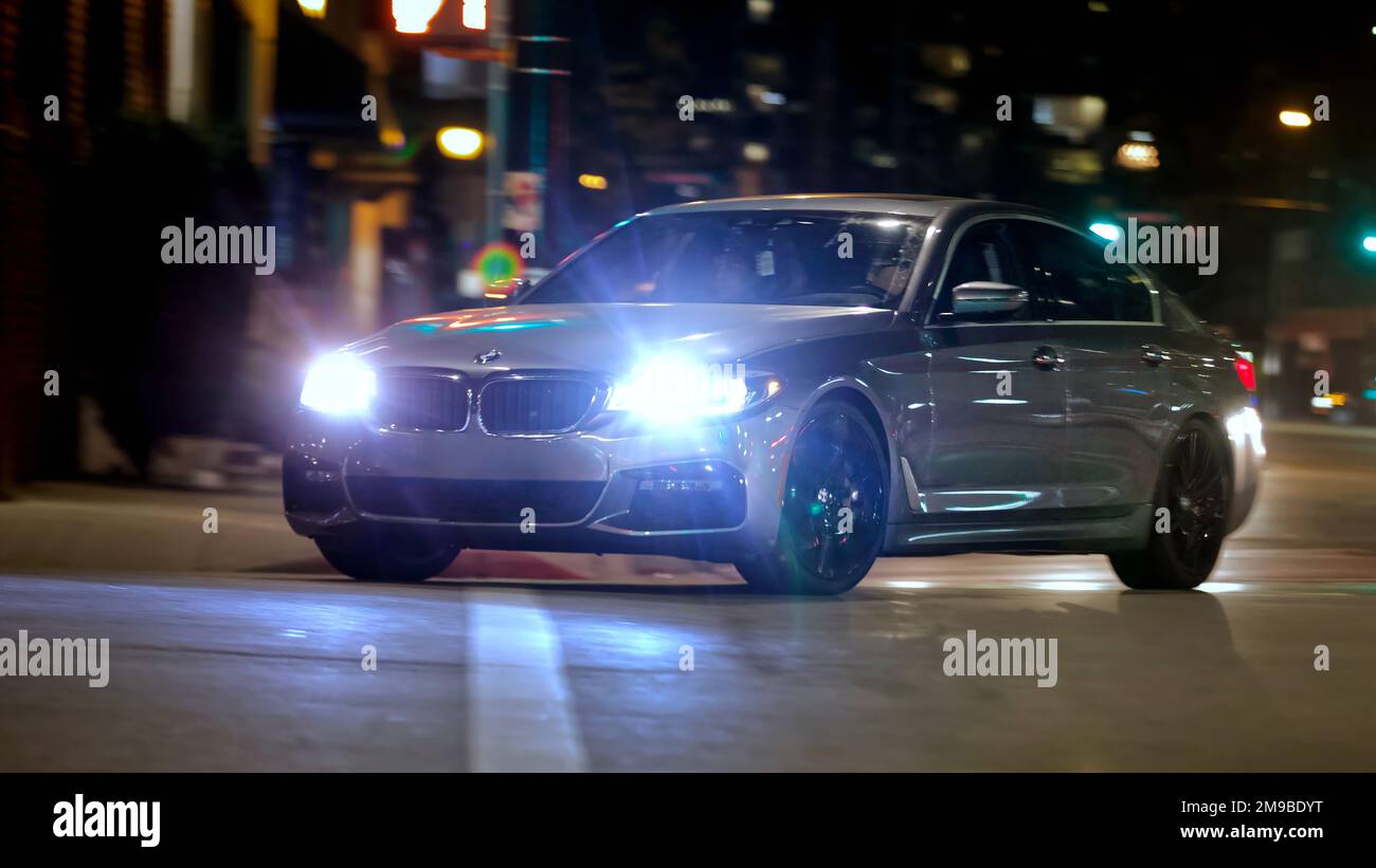 A gray BMW M5 car driving at high speed on the road in the evening ...