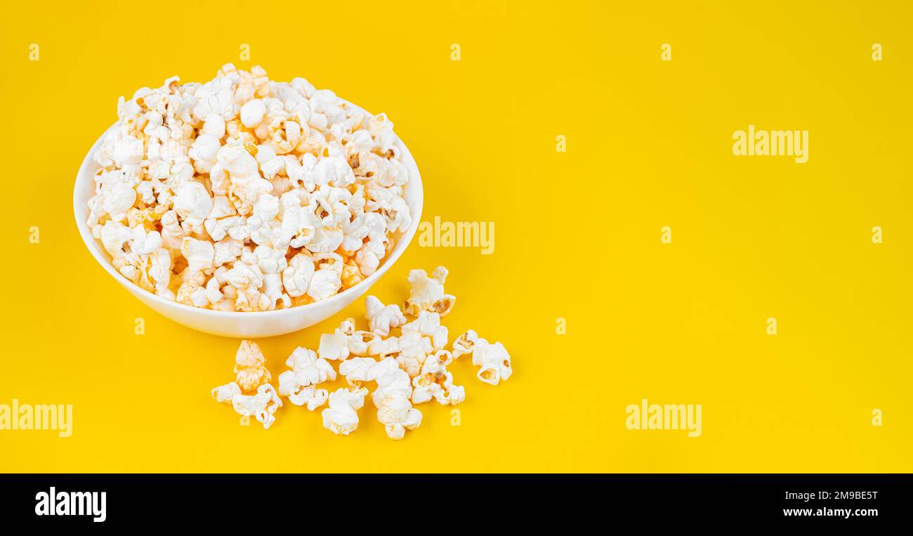 Scattered tasty cheese popcorn in bowl isolated on yellow background ...