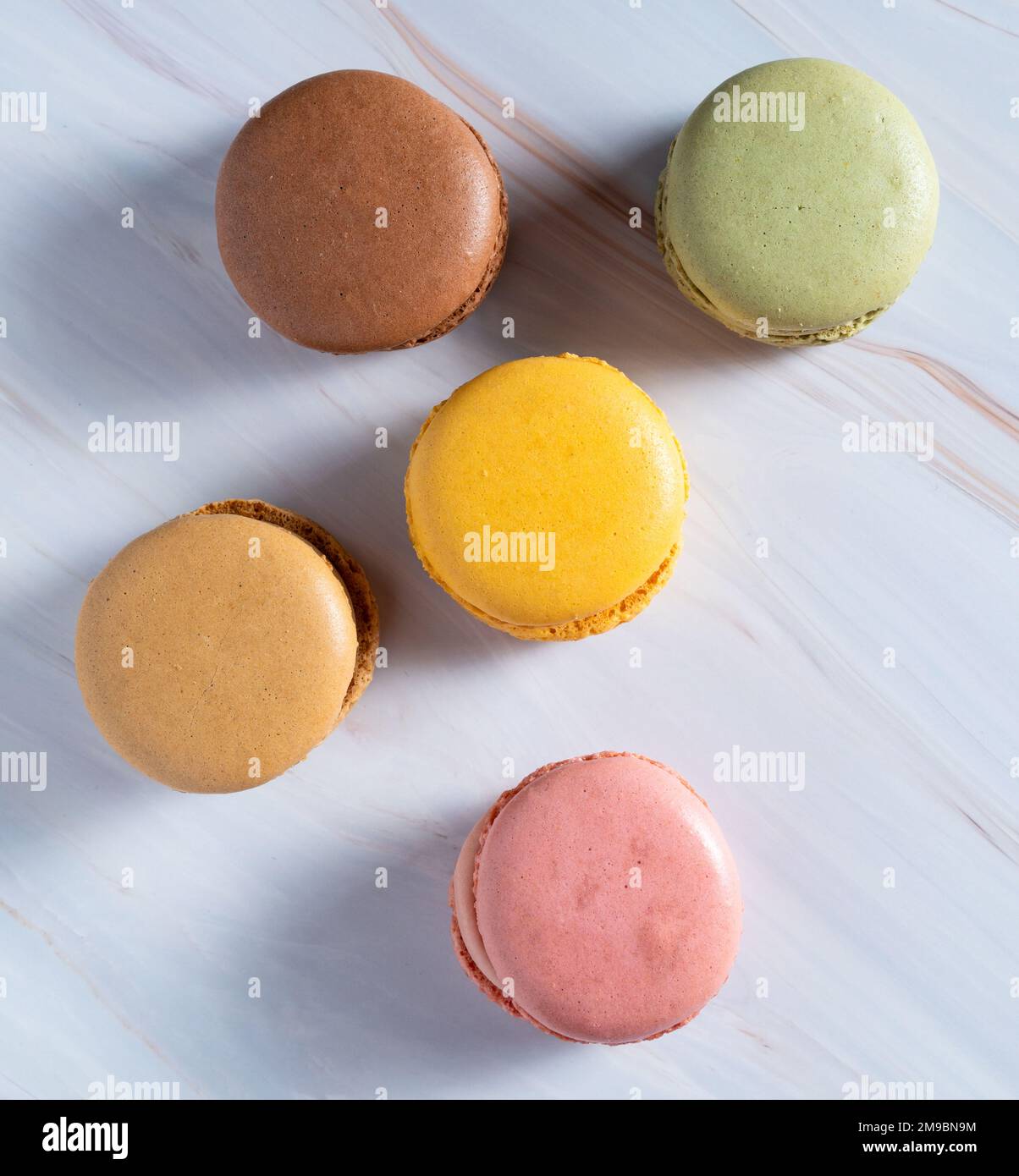 A vertical top view of colorful macarons on a table Stock Photo - Alamy