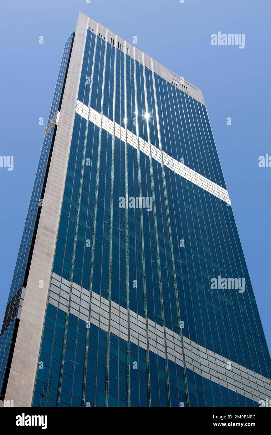 The view of a tall glass covered skyscraper with sunlight reflections ...
