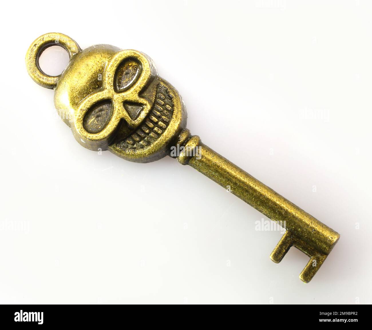 metallic brass key with the symbol of a skull that grinds its teeth ...