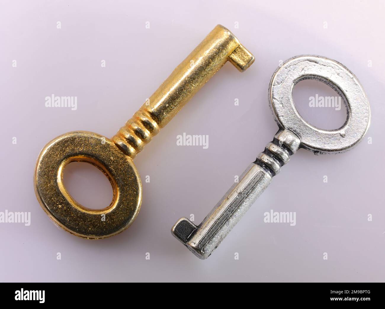 two small metallic key of silver and golden color Stock Photo - Alamy