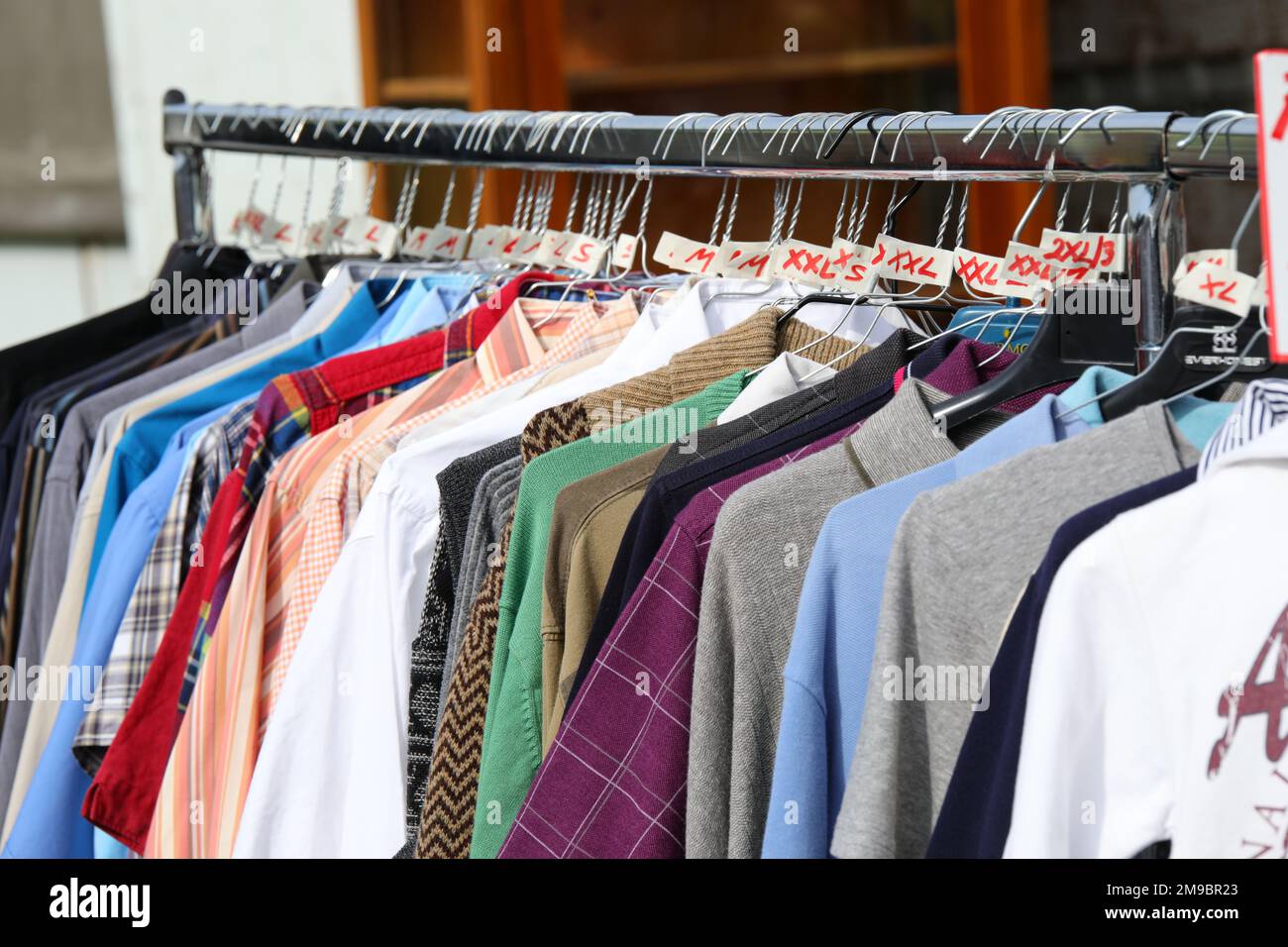 vintage used clothes and new dresses in the stall at the flea market ...