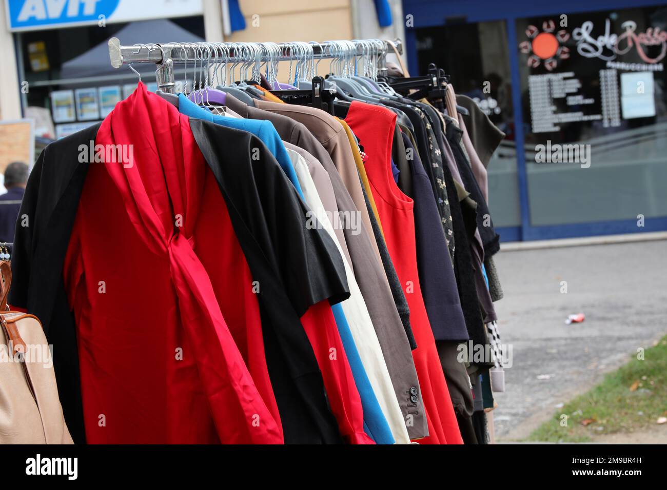 vintage used clothes and new dresses in the stall at the flea market ...