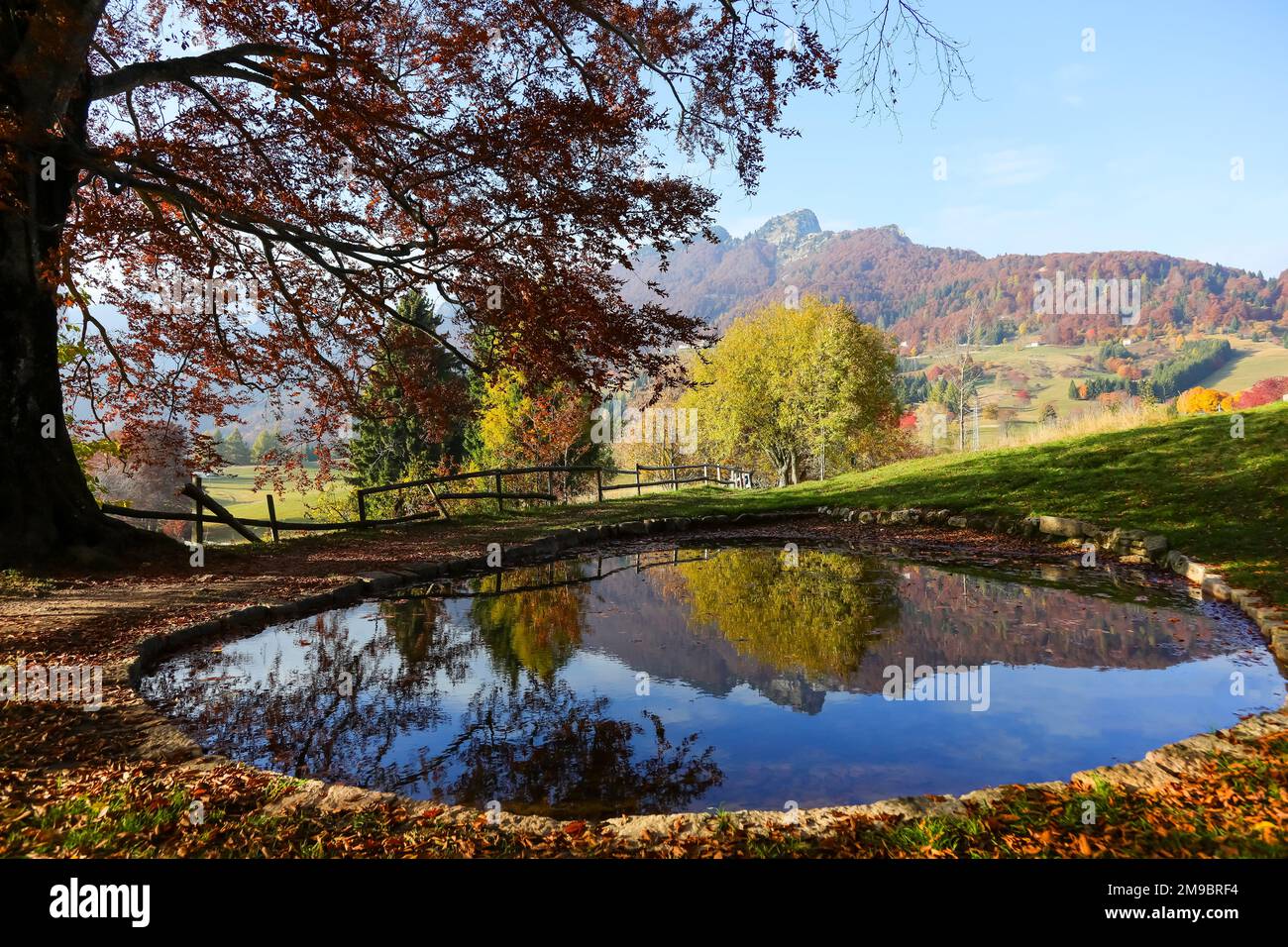 small alpine lake with the reflection of the mountains in the water and ...