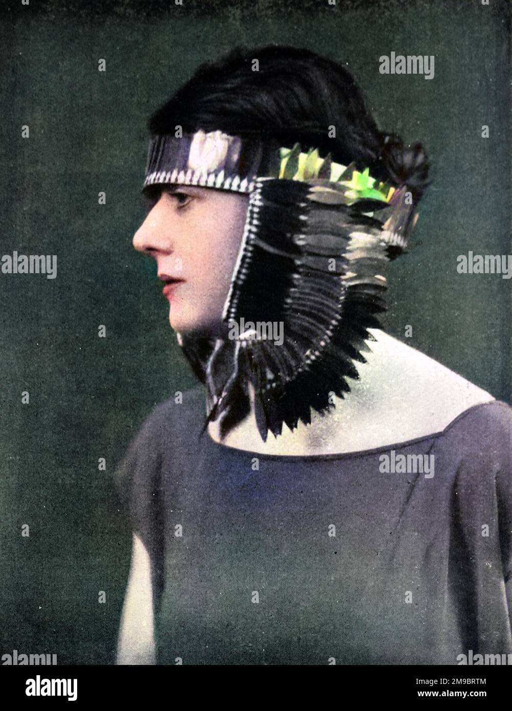 A feathered head dress mounted on a gold bandeau strewn with powdered ...