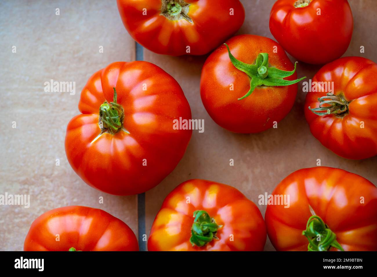 Ripe red tomatoes on a stone floor Stock Photo - Alamy