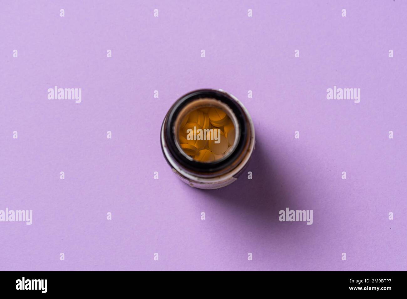 Small pills in a brown glass medicine pill bottle Stock Photo - Alamy