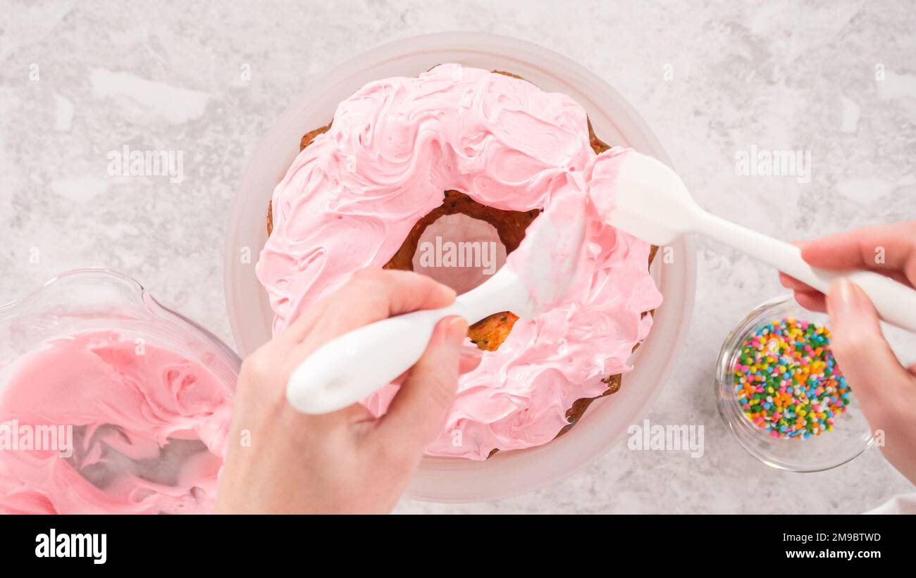 Flat lay. Step by step. Frosting funfetti bunt cake with pink ...