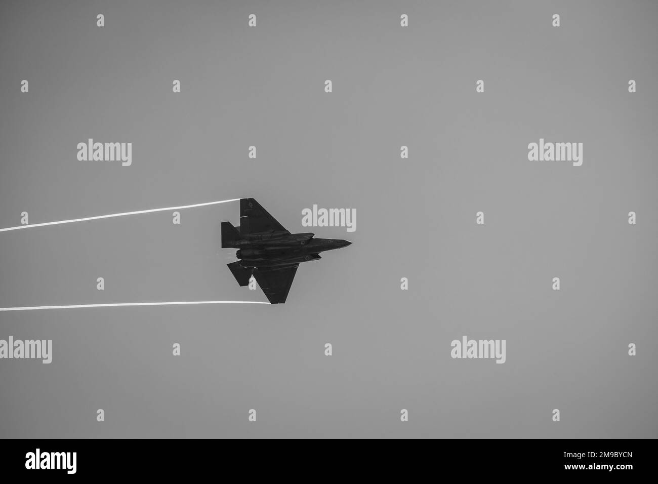 A grayscale of the United States Navy F-35C fighter jet performing a ...