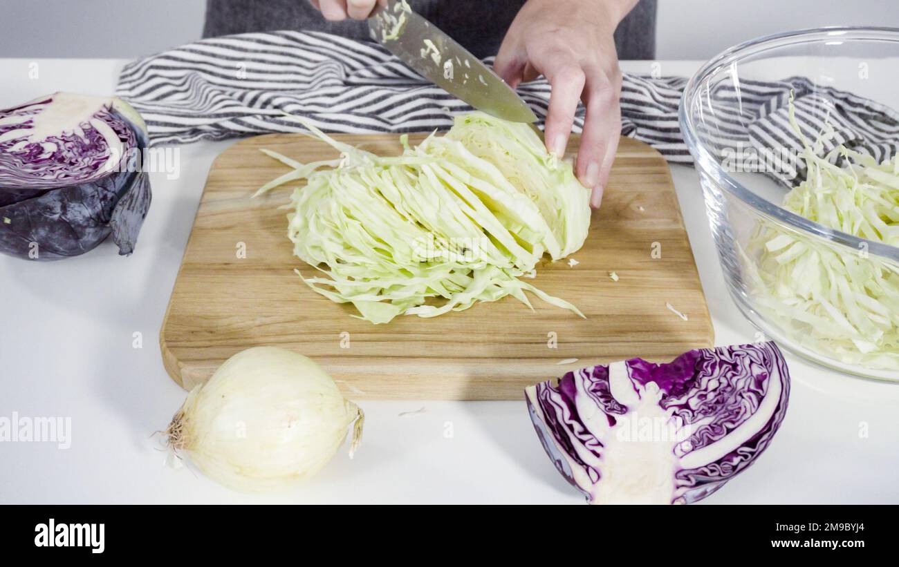 Step by step. Shredding organic cabbage on a wood cutting board Stock ...