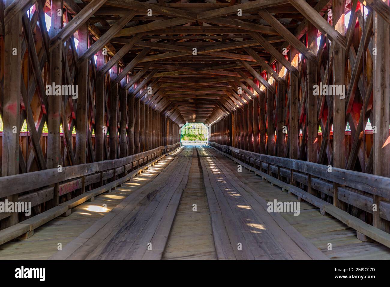 Inside of a red wooden covered bridge located in the Laurentians ...