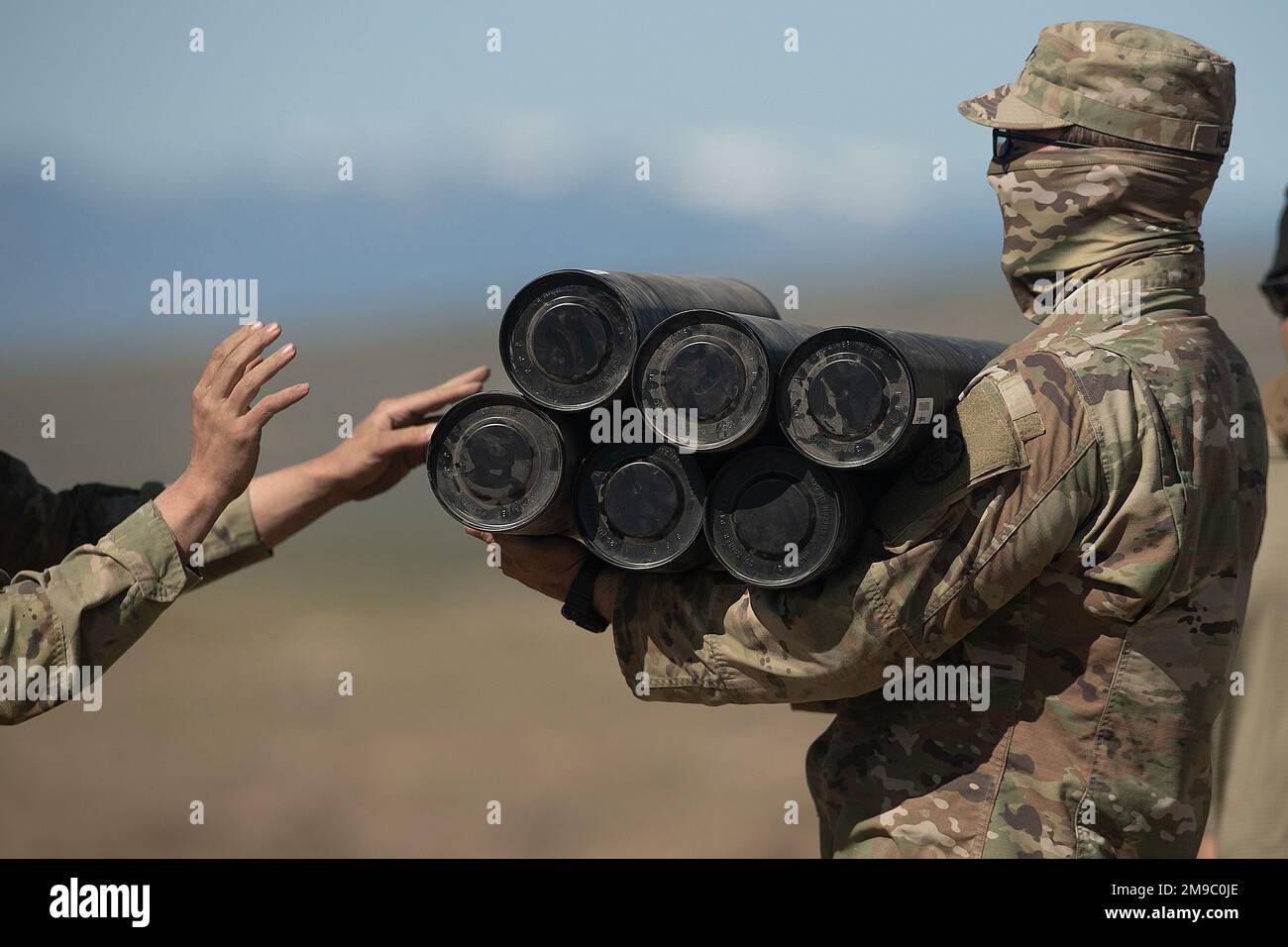 An Idaho Army National Guard Soldier carries a stack of empty cartridge ...