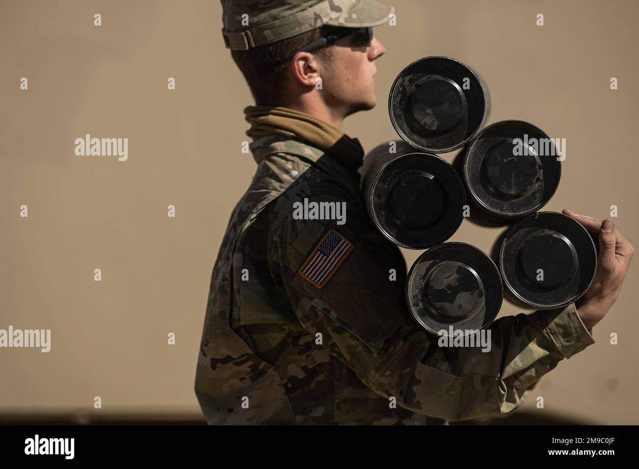 An Idaho Army National Guard Soldier carries a stack of empty cartridge ...