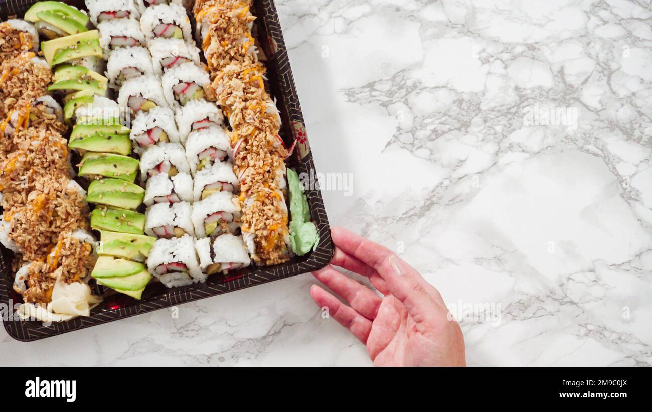 Flat lay. Pre-packaged variety of sushi and sushi rolls in a plastic ...