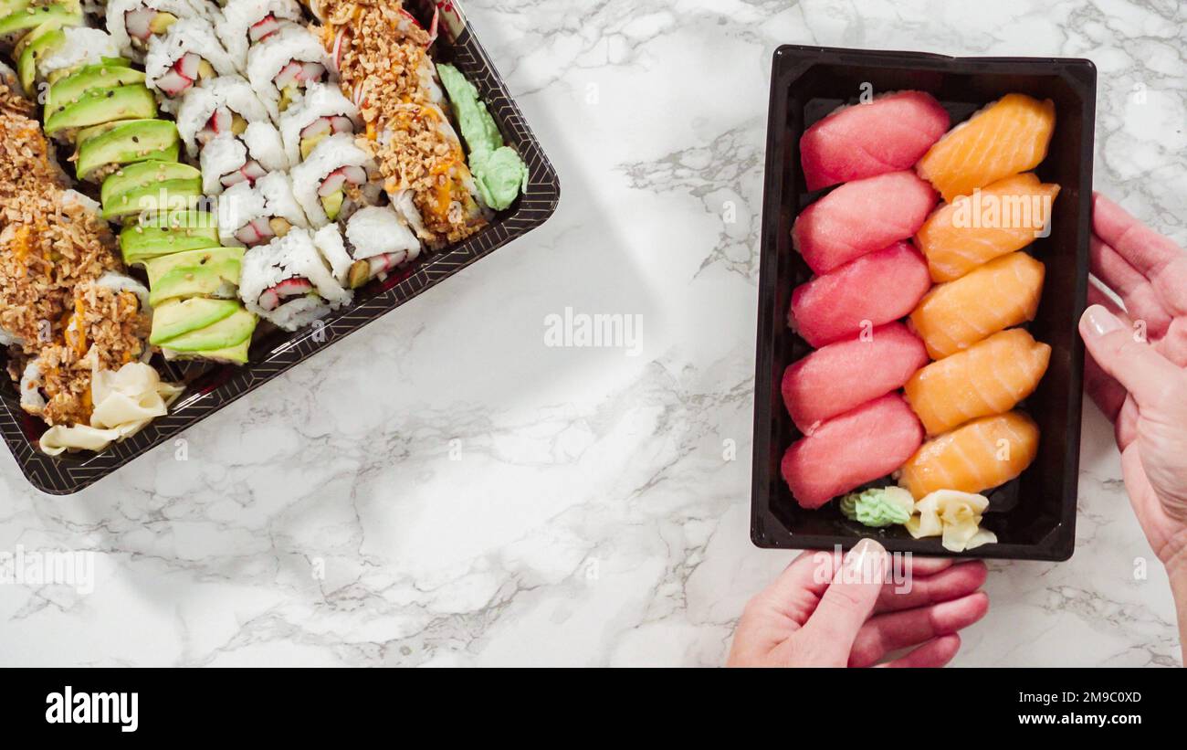 Flat lay. Pre-packaged variety of sushi and sushi rolls in a plastic ...