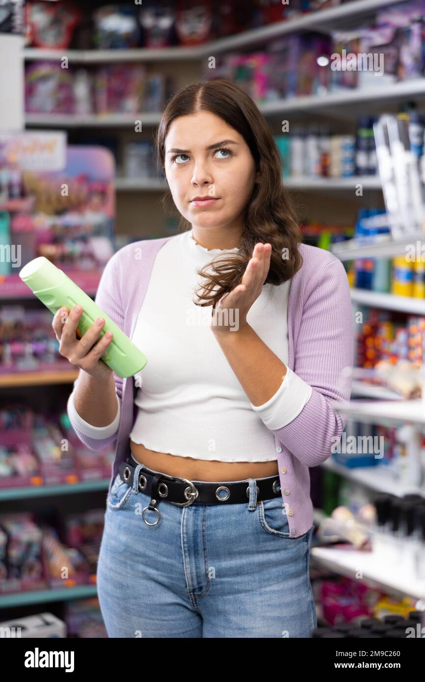 Beautiful european woman buying shampoo or hair care products in ...