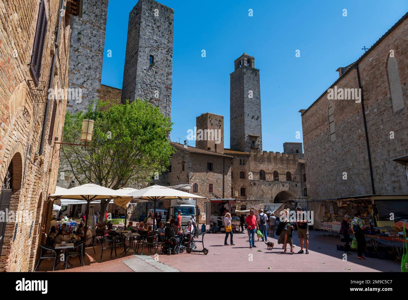 Tourists enjoy historic architecture walking at Piazza Della Cisterna ...