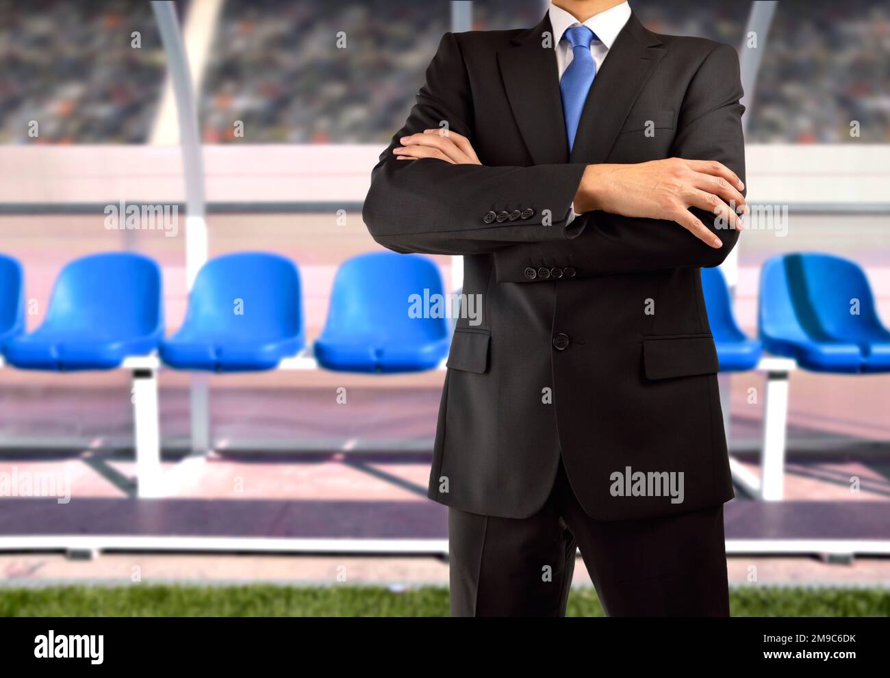 Coach with arms crossed waiting for the start of the match at stadium ...