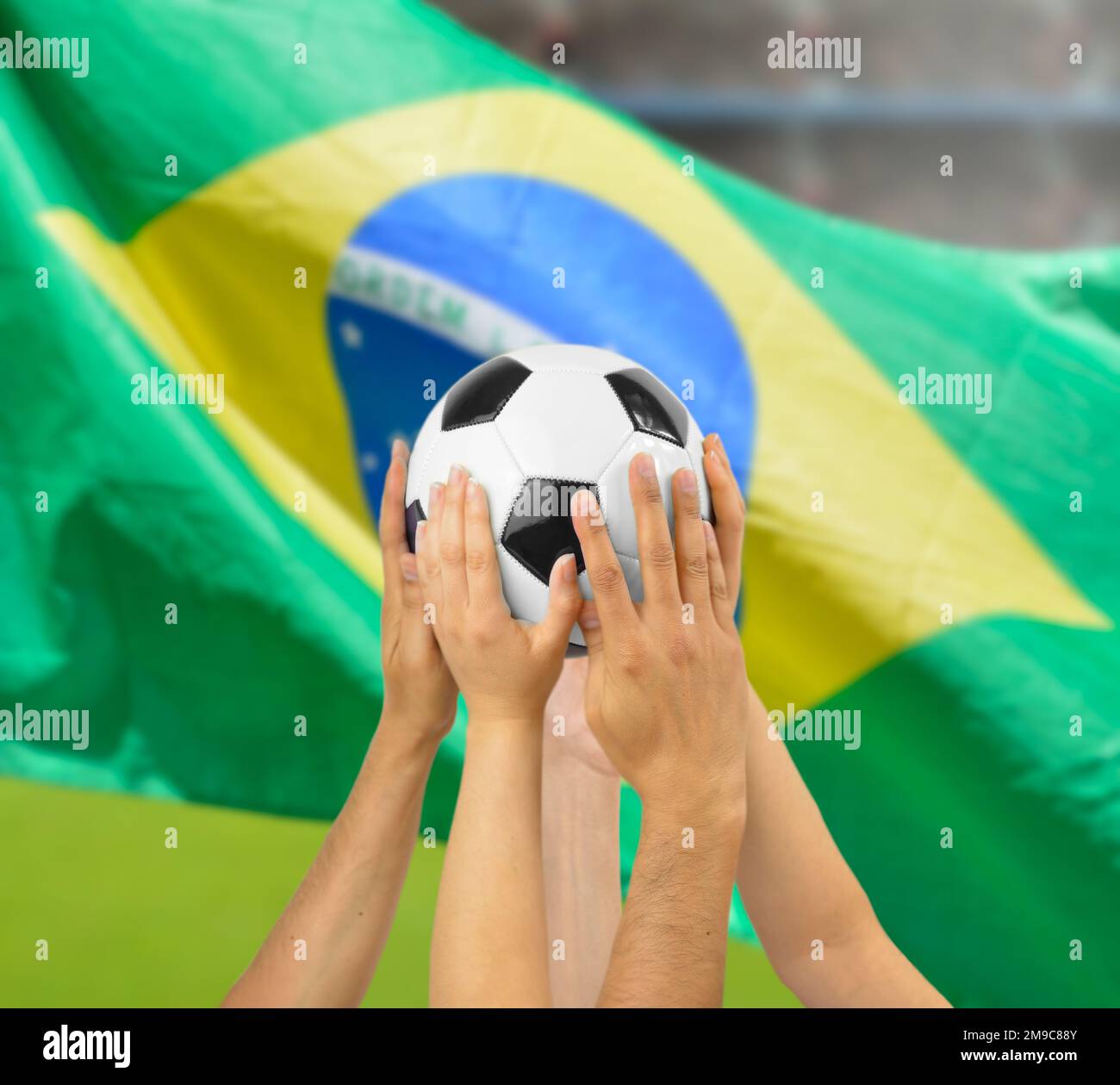 Group of football players holding a soccer ball at football stadium ...