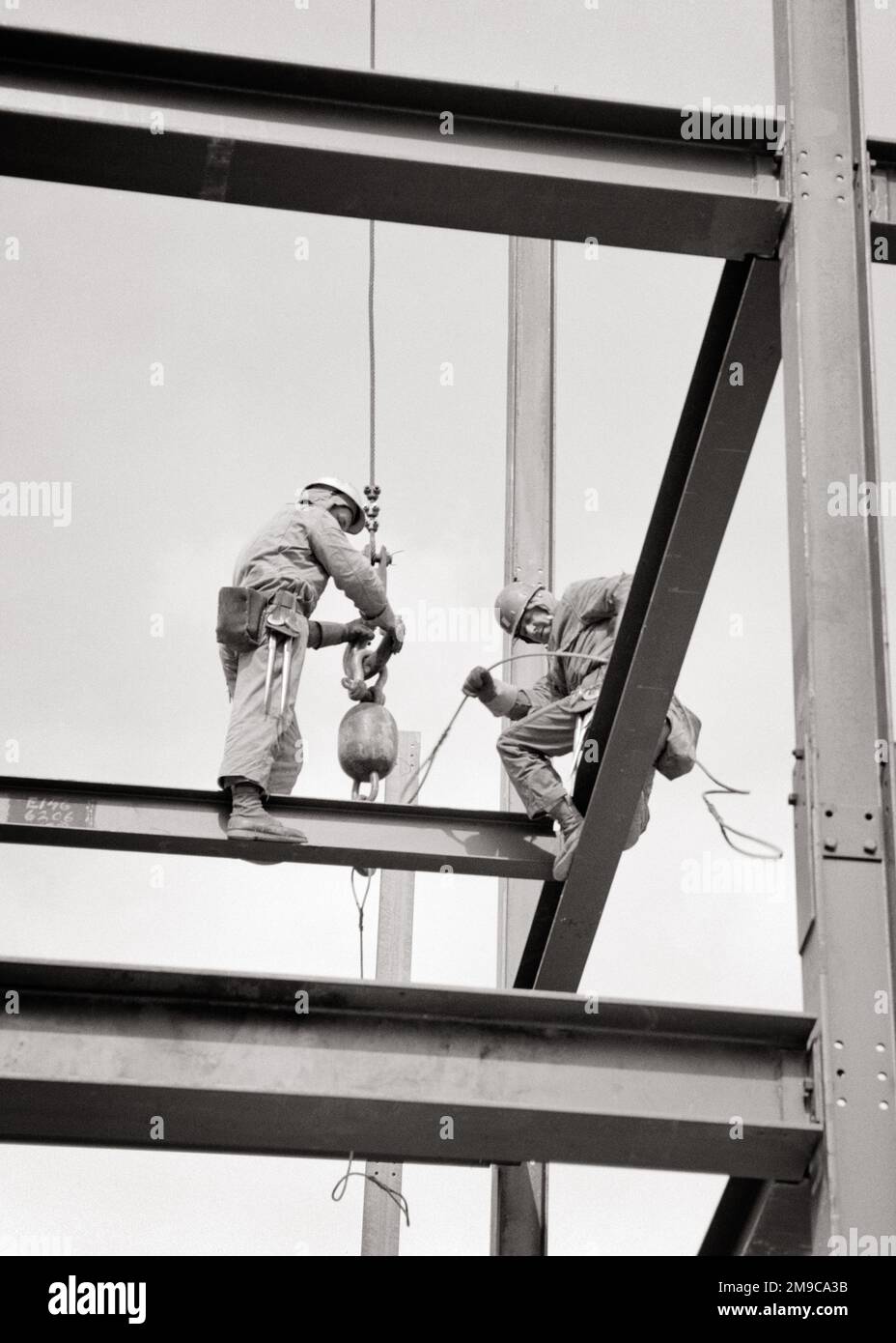 1960s TWO MEN WORKING TOGETHER ON STEEL I-BEAM BUILDING CONSTRUCTION ...