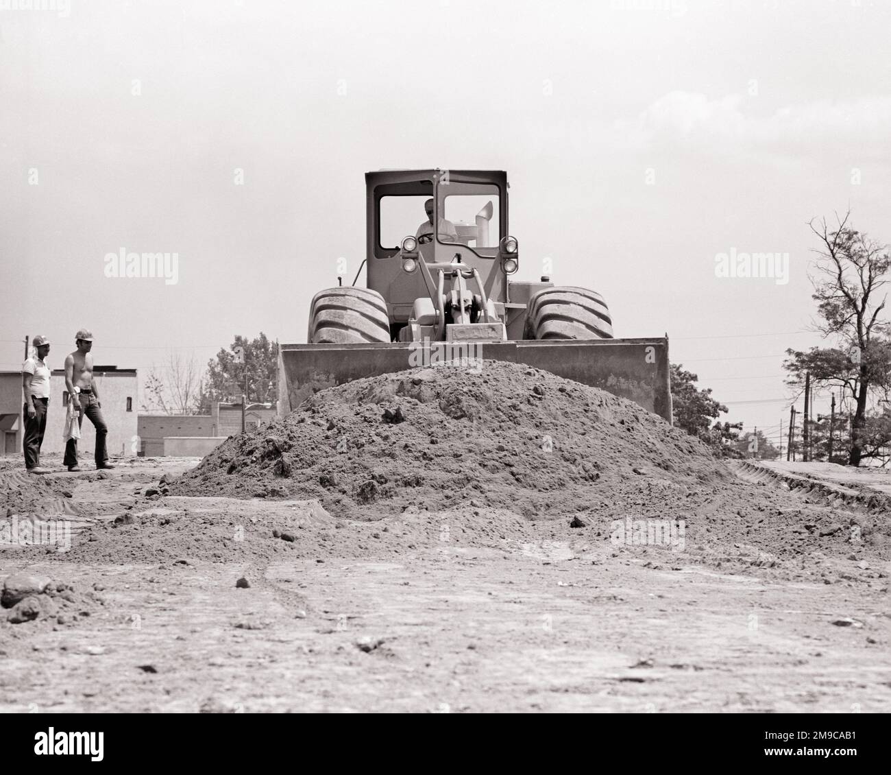 1970s TWO MEN SUPERVISING THIRD ON WHEELED FRONT END LOADER BULLDOZER ...