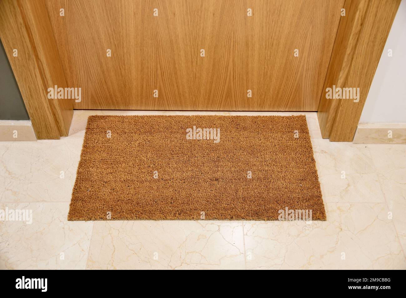 Brown welcome mat at front door Stock Photo - Alamy